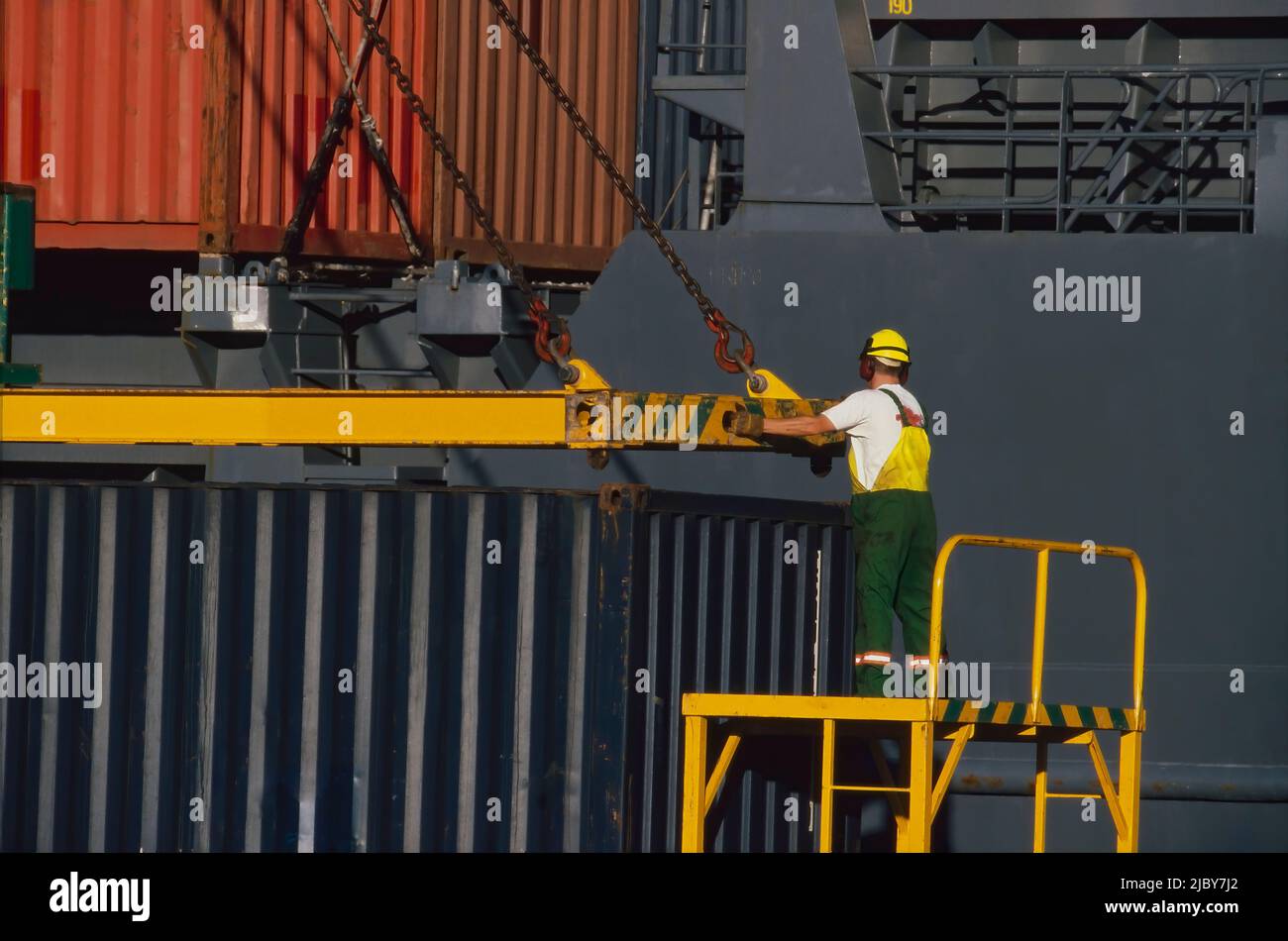 Man securring shipping container for loading on ship Stock Photo - Alamy