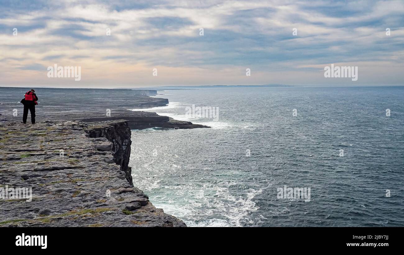 Man taking photo of the cliffs of Aran Island, Ireland Stock Photo - Alamy