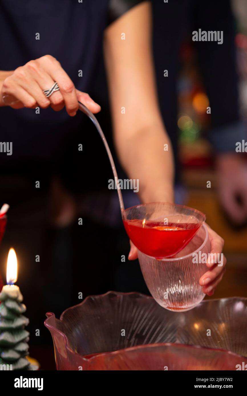 Detail of woman filling cup from punch bowl at festive Christmas party ...