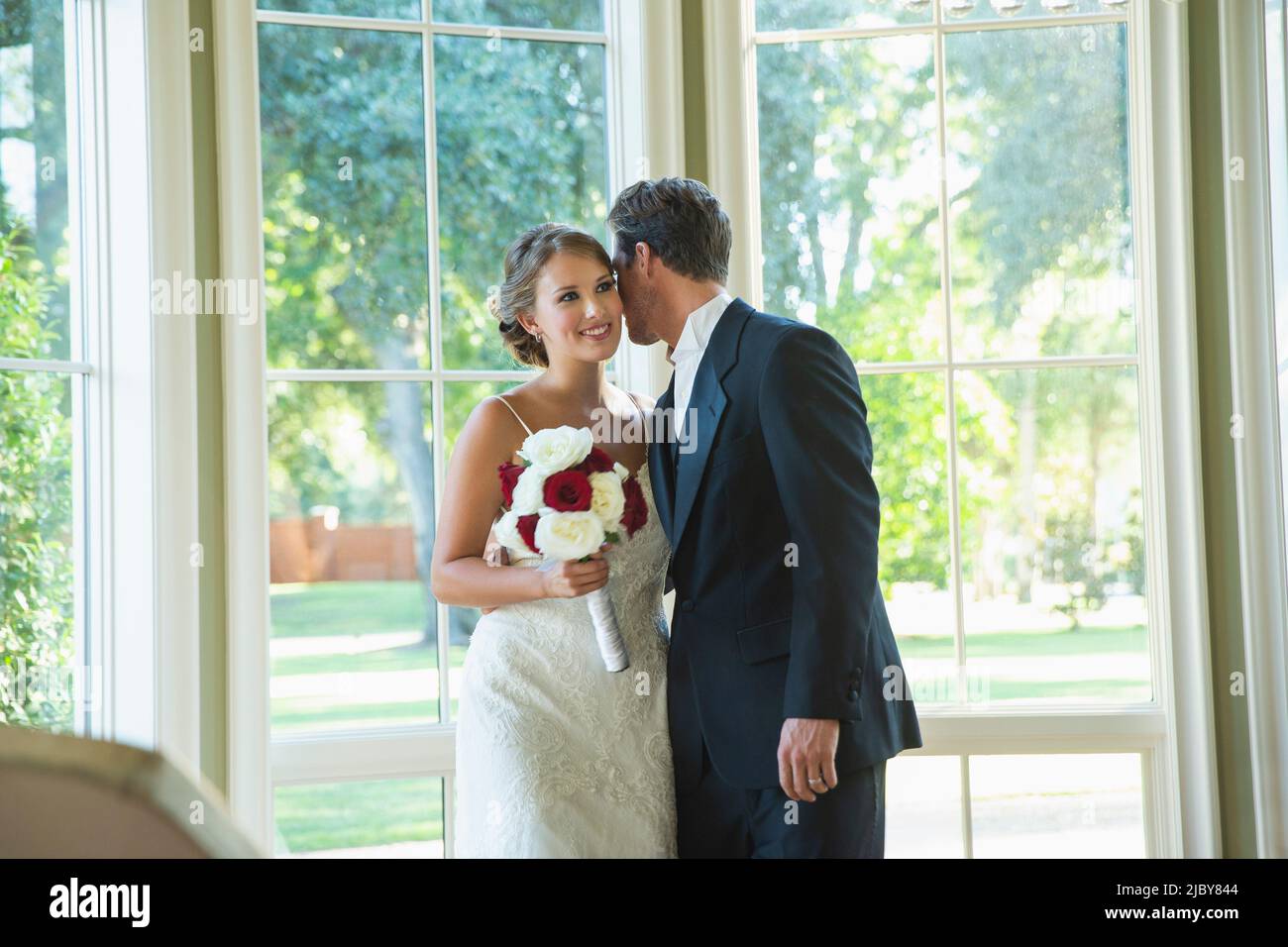 Bride and Groom about to walk into reception, groom whispering in ...