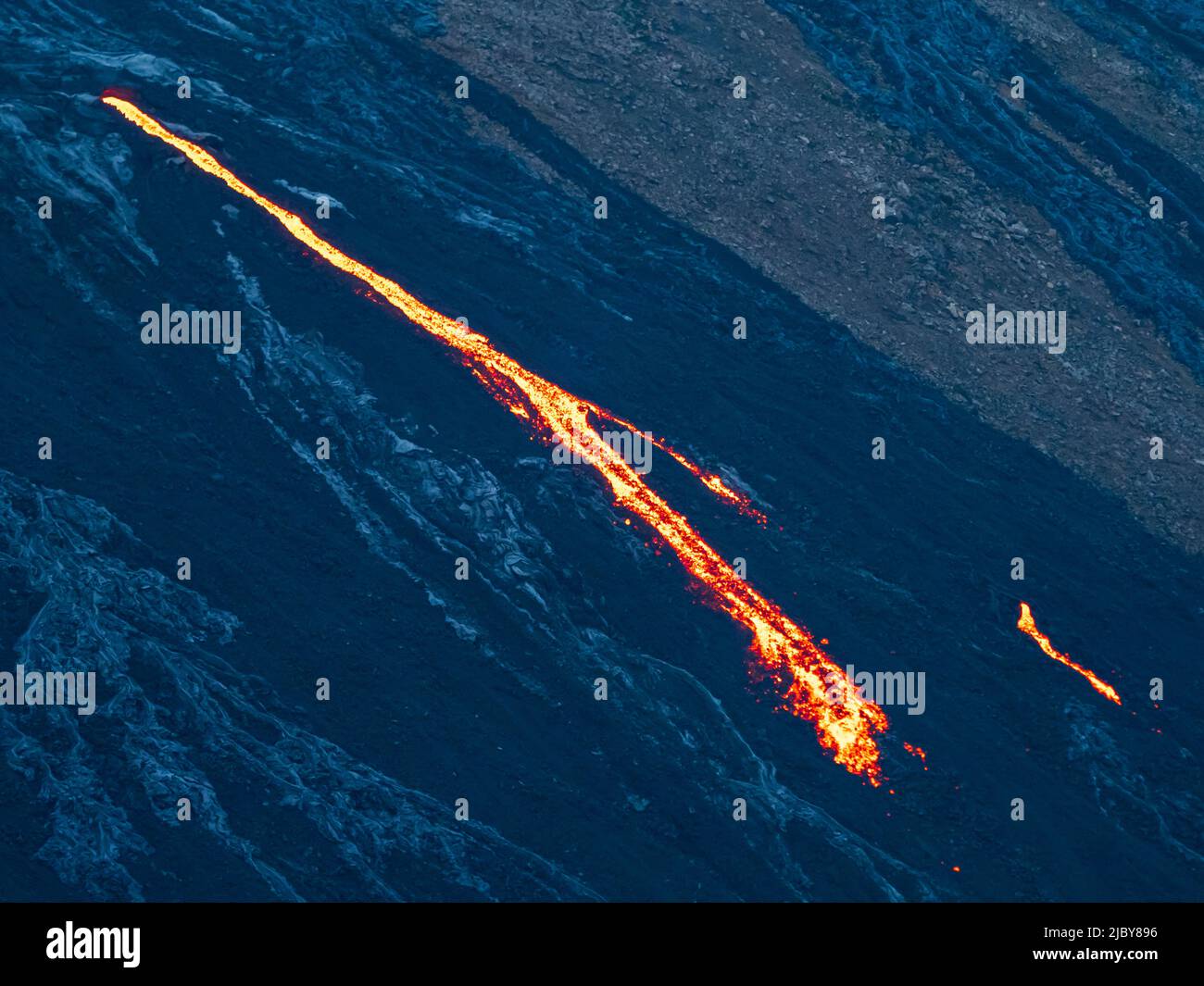 Glowing Lava cascade spilling from lava tube from Fagradalsfjall ...
