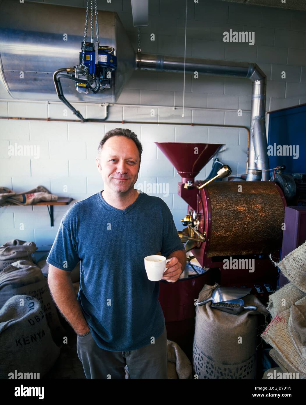 Portrait of coffee master roaster sampling cup of coffee in roasting ...