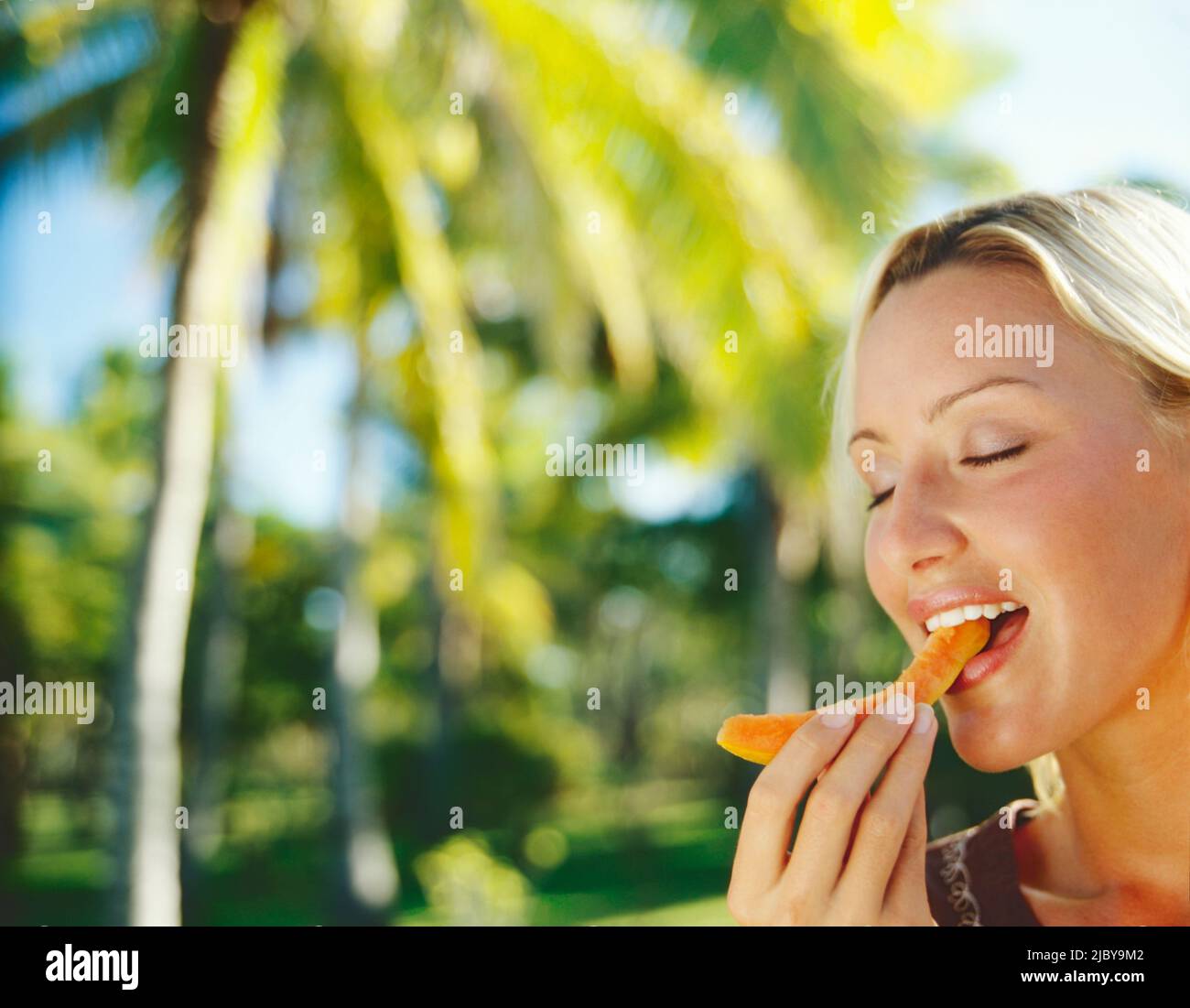 Woman eating Papaya on tropical island Stock Photo - Alamy