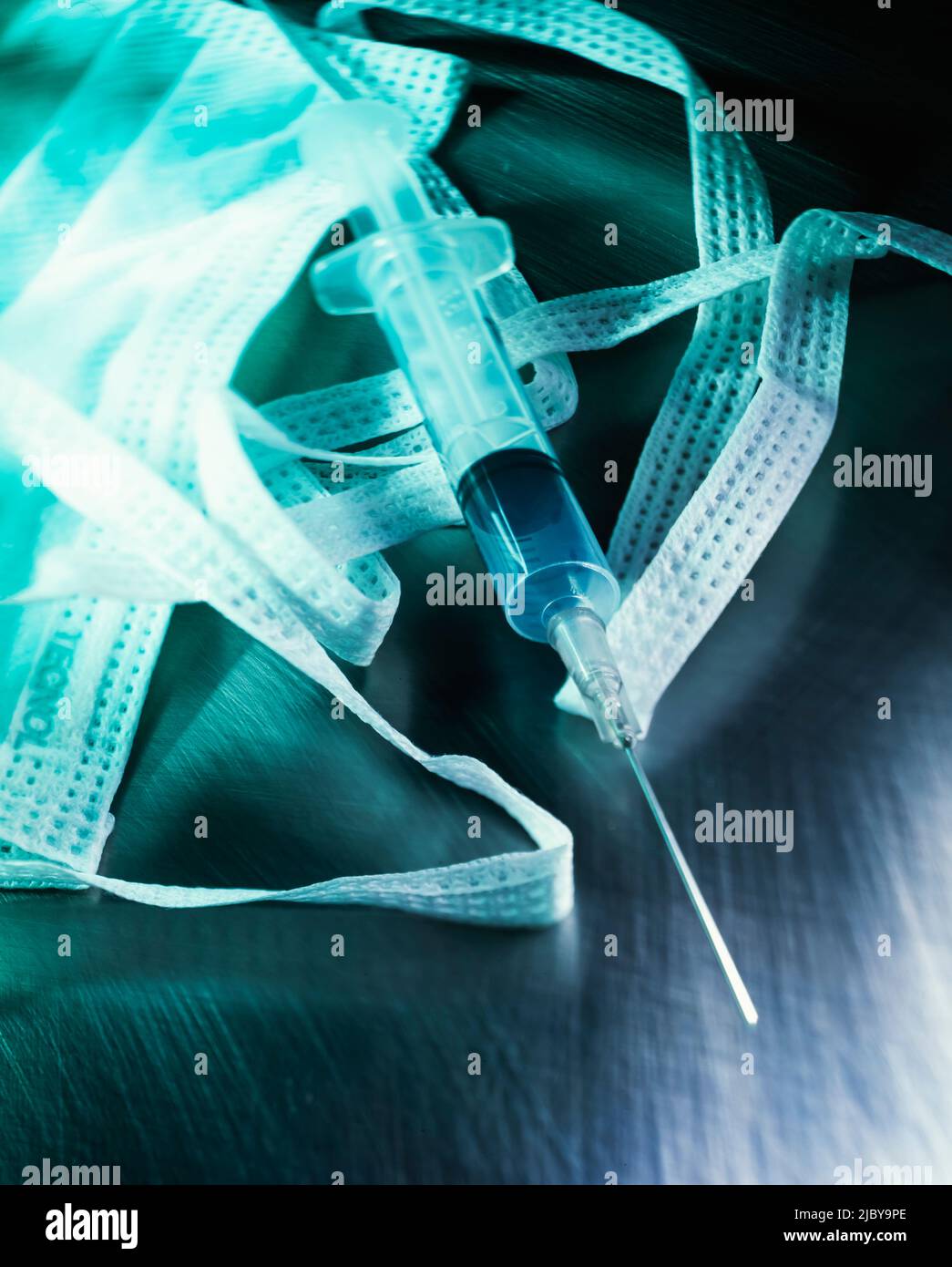 Syringe and surgical masks on steel bench Stock Photo - Alamy