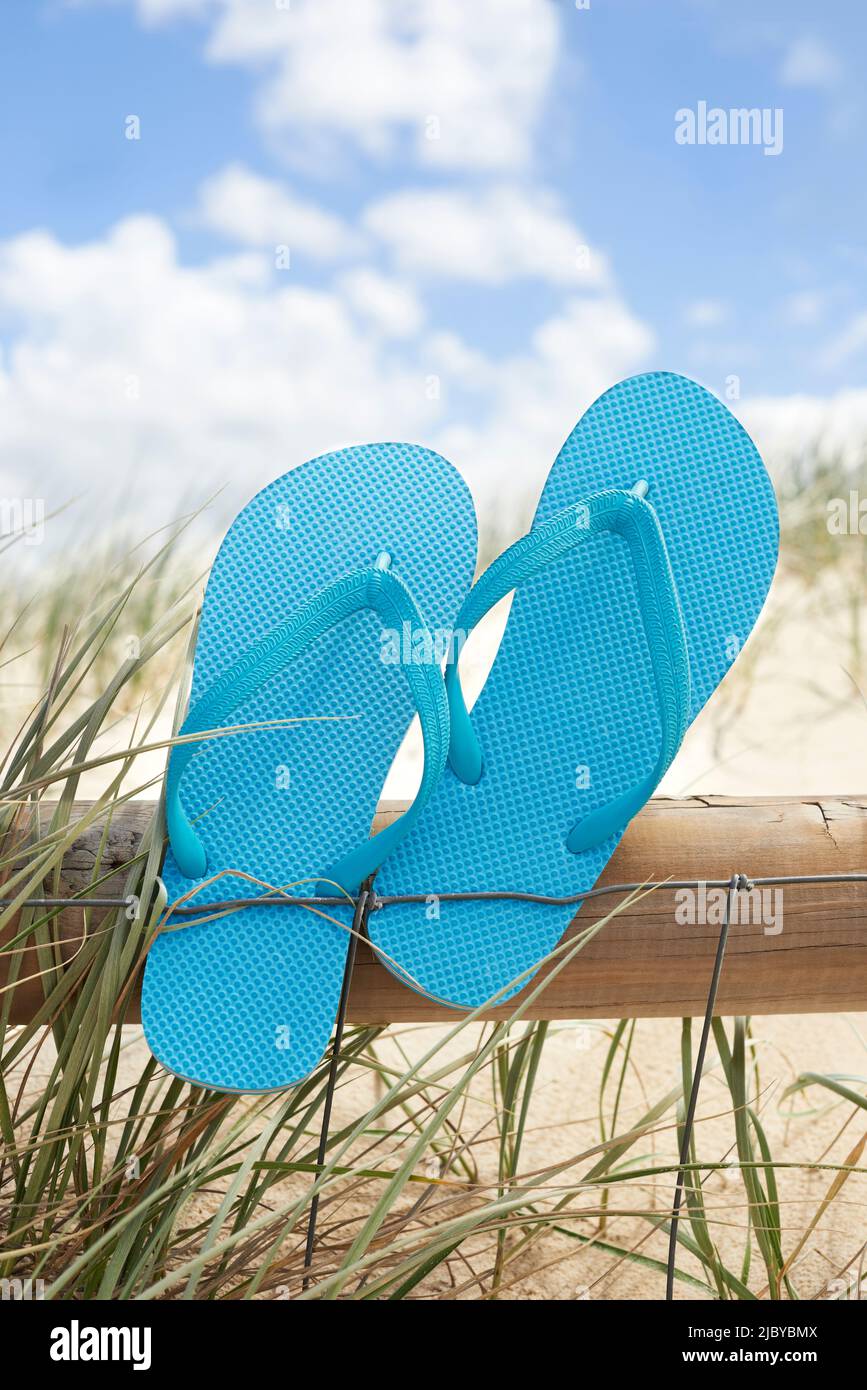 Flip flops wedged between wire and wooden railing at the beach Stock ...