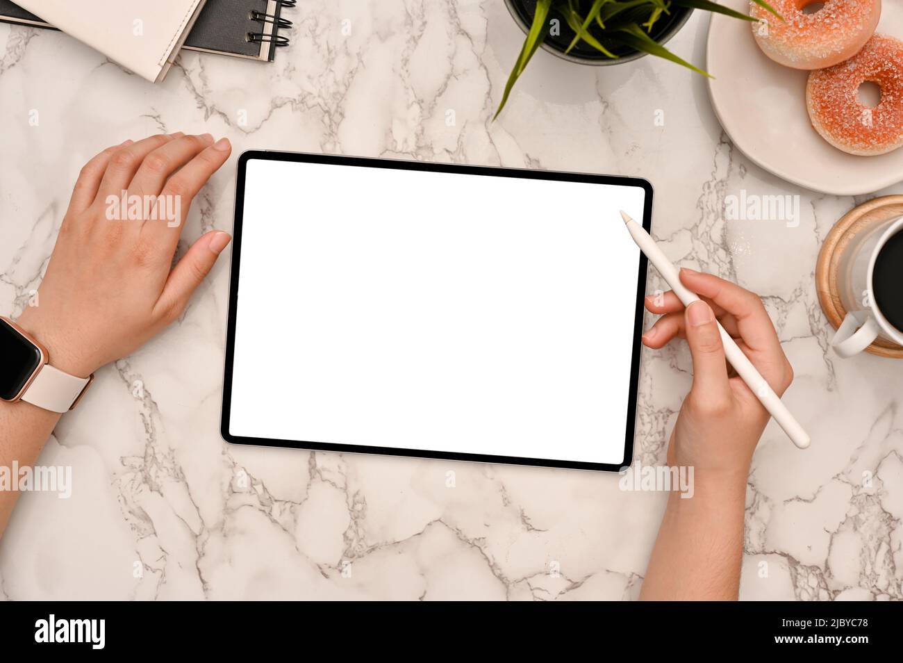 Above view, A woman draws and sketches her design on a tablet with a ...