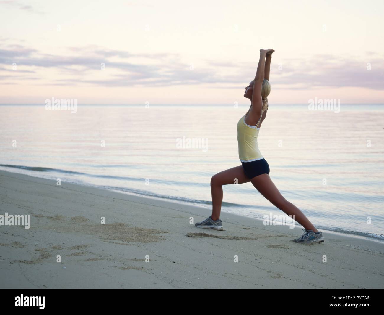 Young woman stretching on tropical beach Stock Photo - Alamy