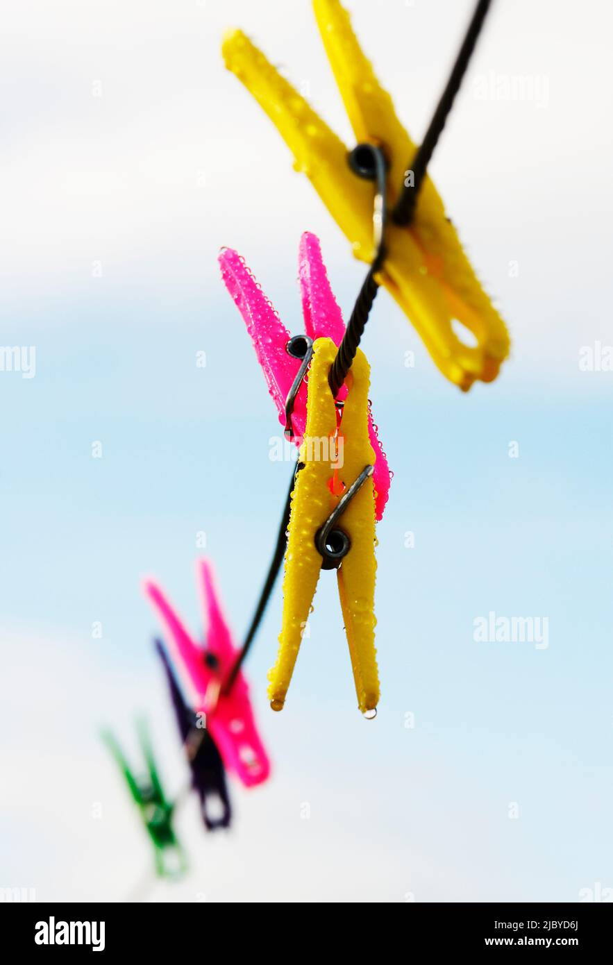Different coloured pegs clipped on washing line Stock Photo - Alamy