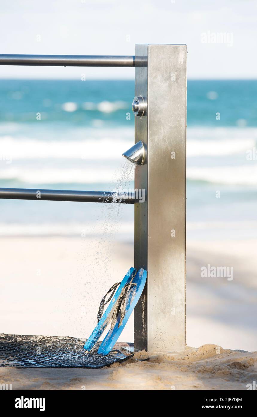 Foot shower sprinkling water on a pair of flip flops at the beach Stock ...