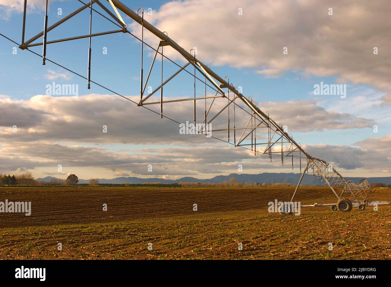 Moveable Irrigation boom sprinkler system in large ploughed field Stock ...