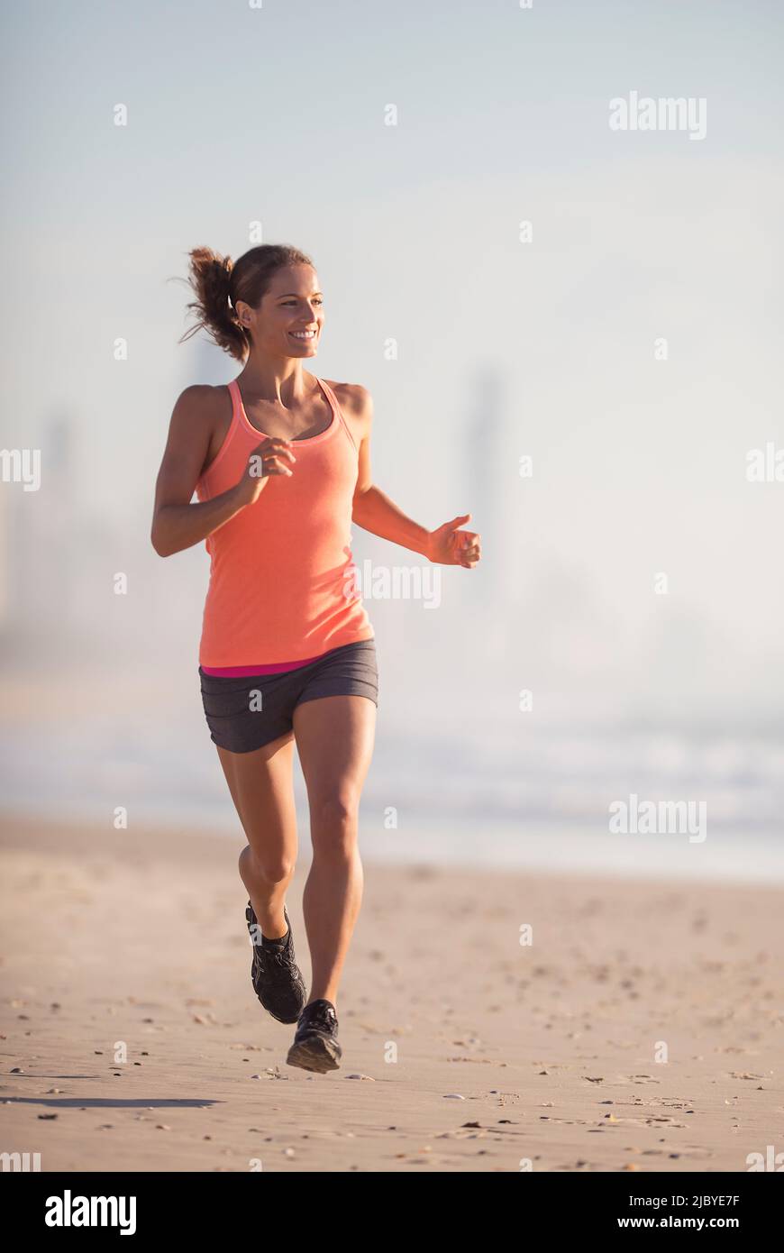 Young woman running on the beach Stock Photo - Alamy
