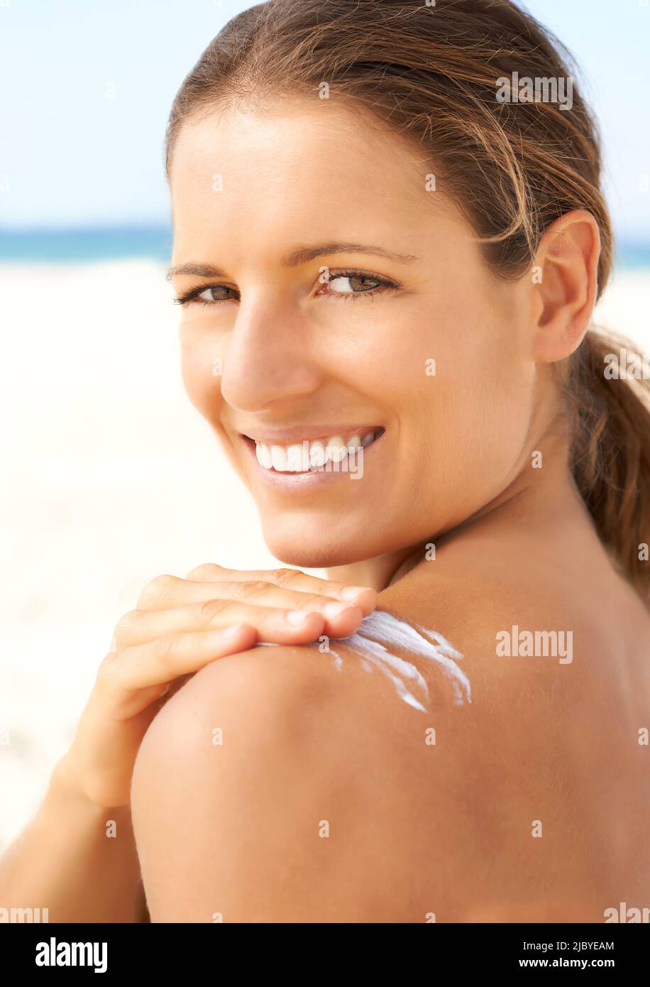 Portrait Of Healthy Beautiful Young Woman Applying Sunscreen To Her