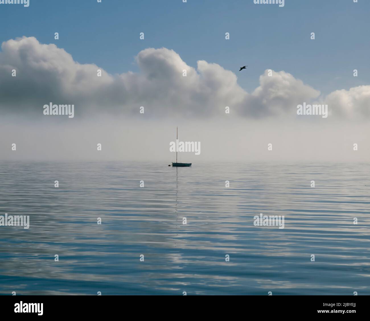 Small boat floating on rippling blue water and sea mist rolling in ...