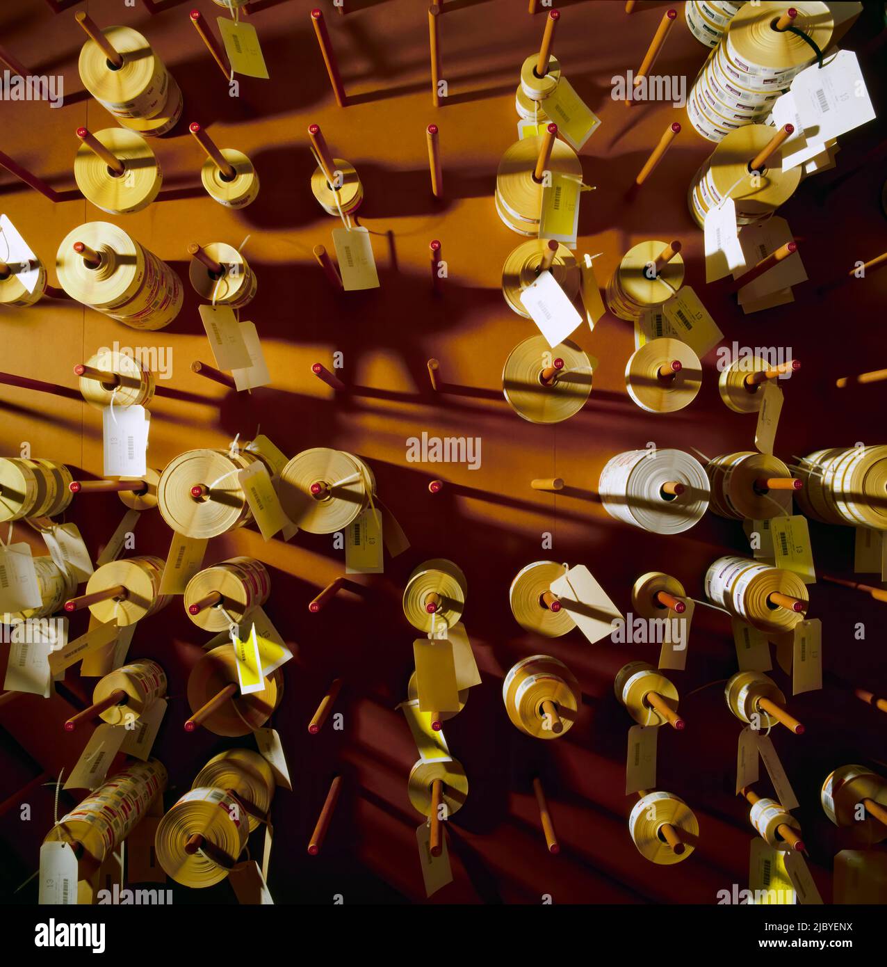 Wooden rack holding different rolls of labels Stock Photo - Alamy