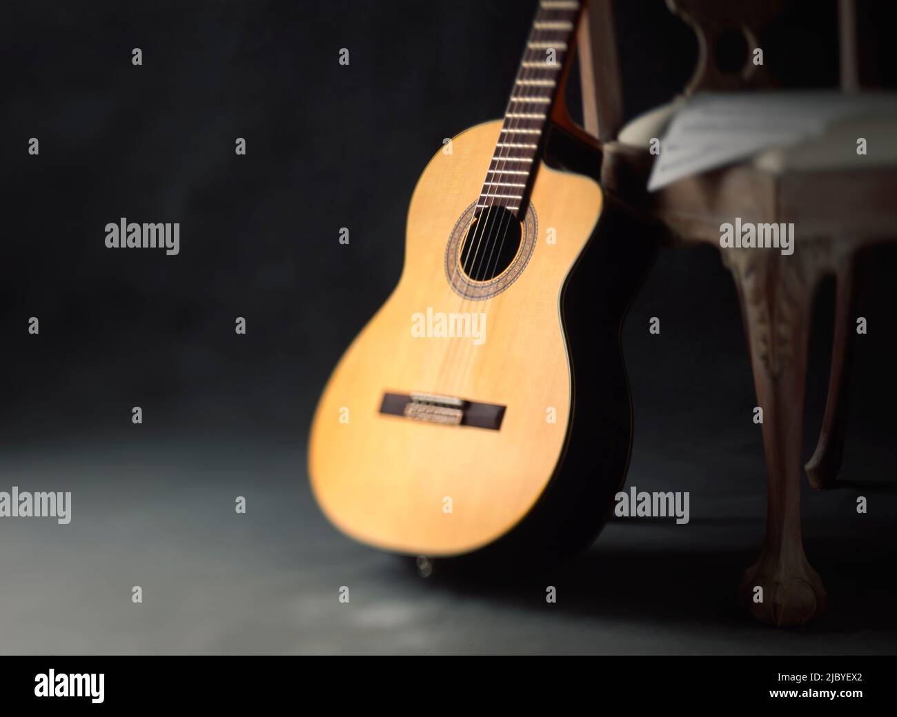 Classical Guitar leaning against chair with sheet music Stock Photo - Alamy