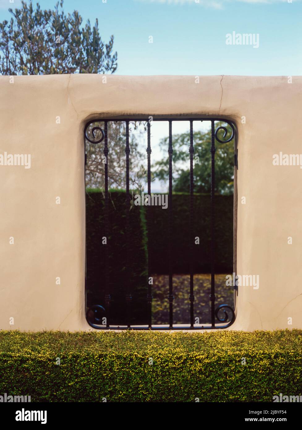 Barred window in outside wall looking through to garden Stock Photo - Alamy