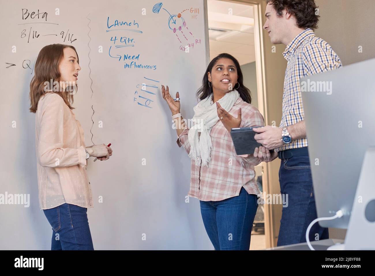 Co-Workers mapping out ideas and strategy with flowchart on dry erase ... Co-Workers mapping out ideas and strategy with flowchart on dry erase ...