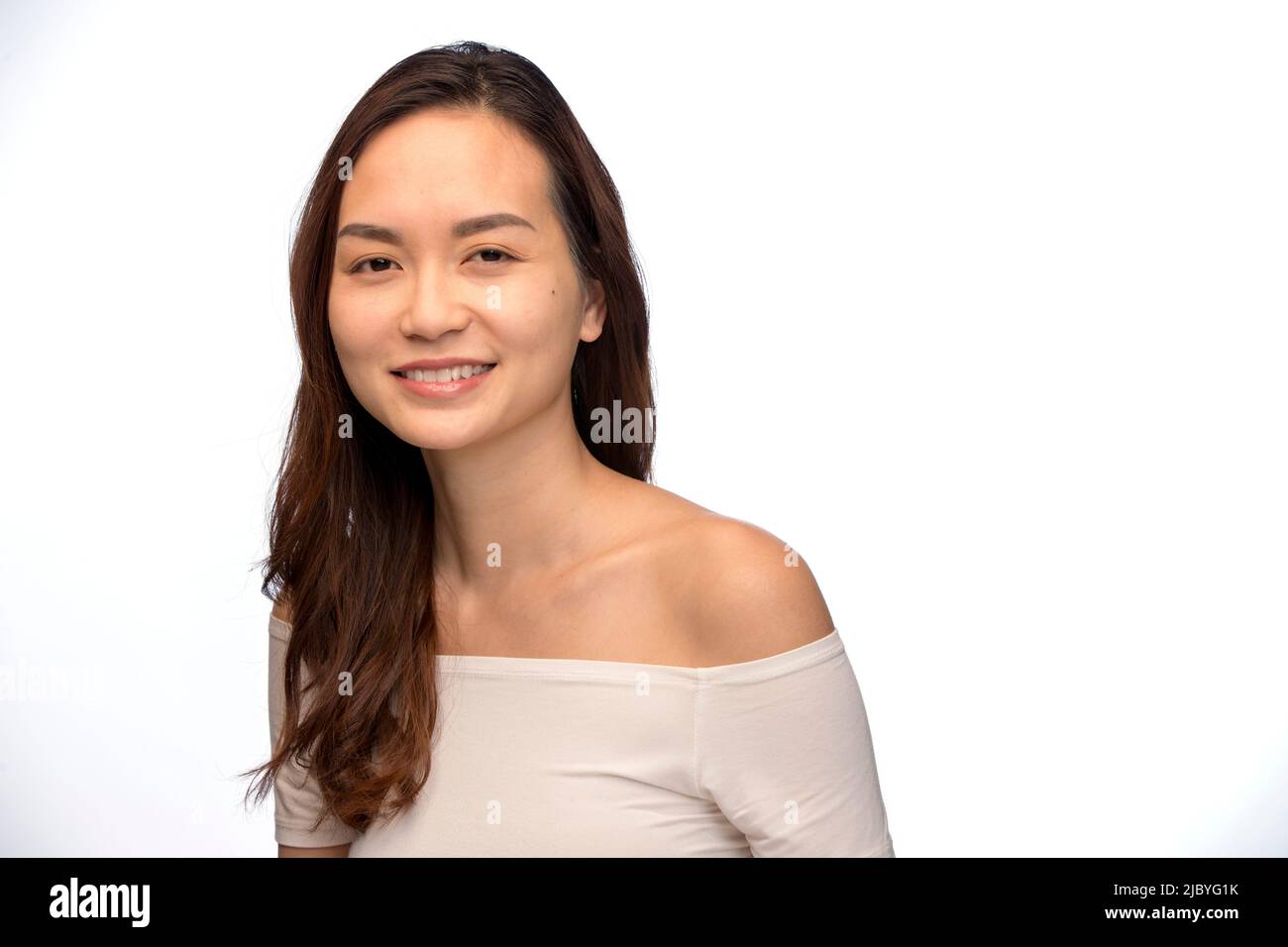Portrait of young woman of Asian descent looking at camera smiling ...