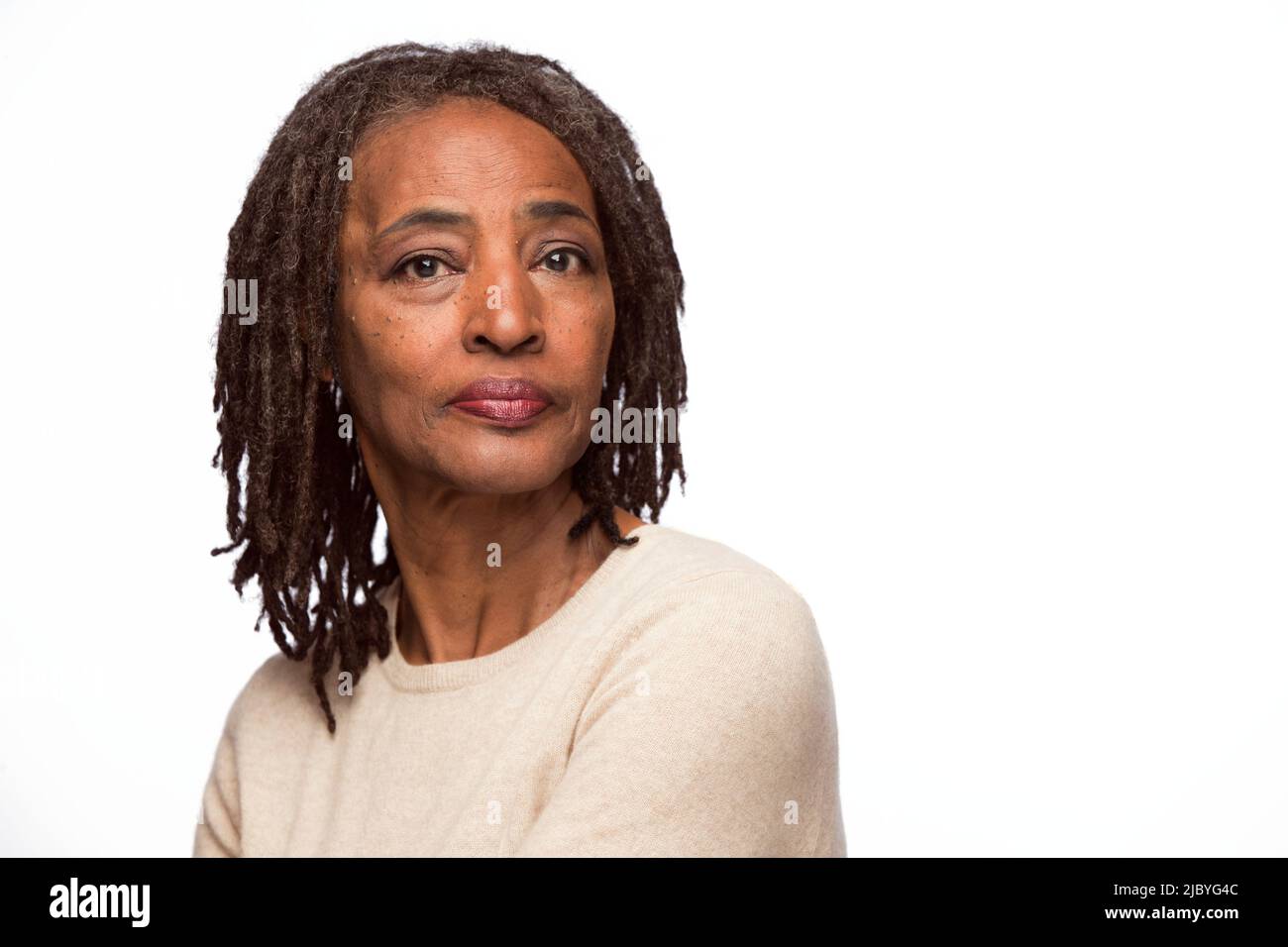 Portrait of older black woman looking at camera over shoulder with ...