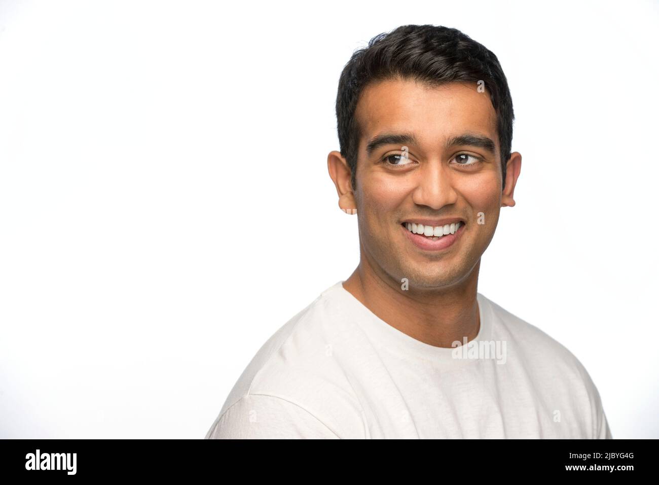 Portrait of young Indian man looking off camera smiling Stock Photo - Alamy