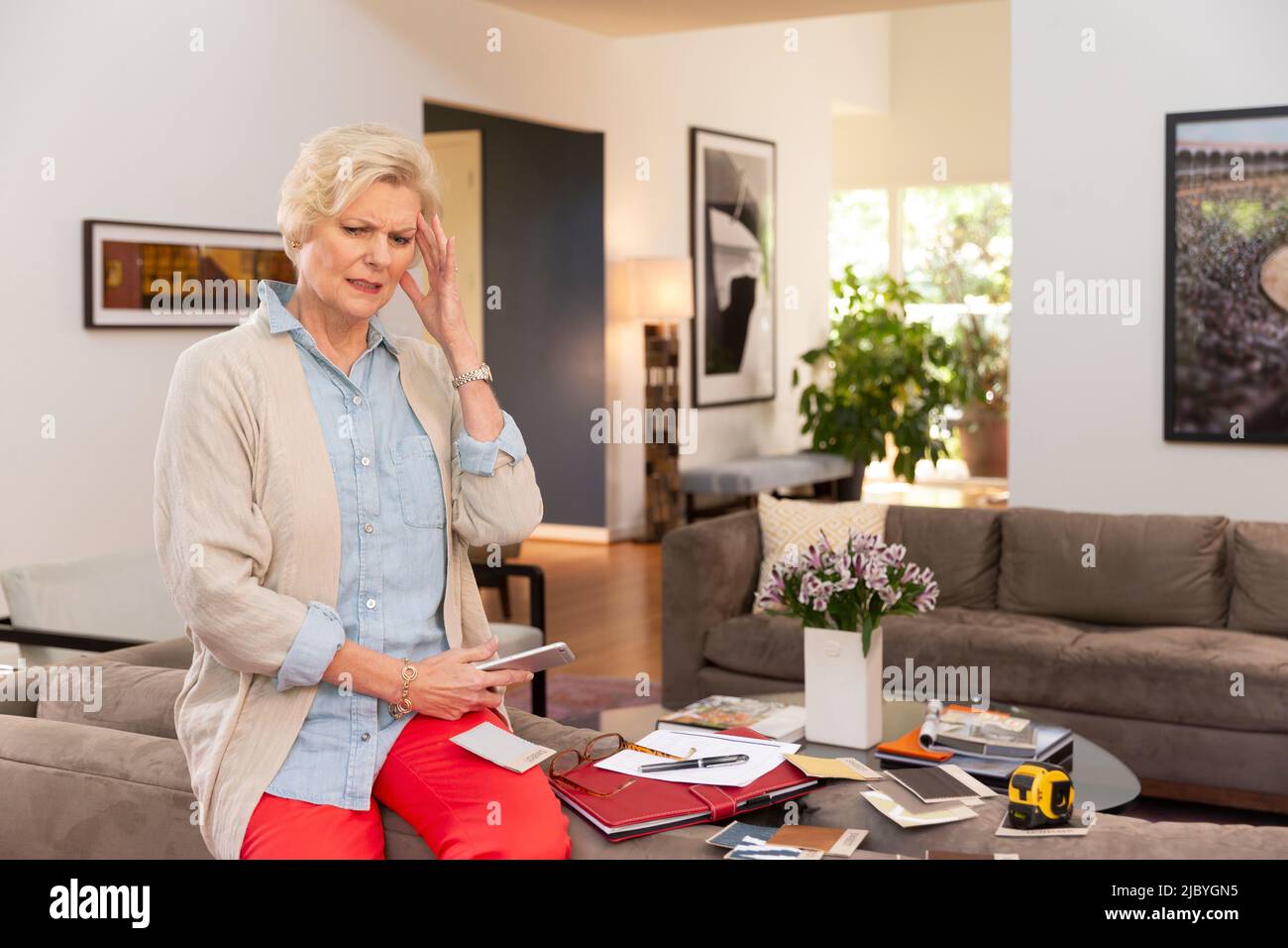 tting on back of couch with fabric swatches and notes laid out around ...