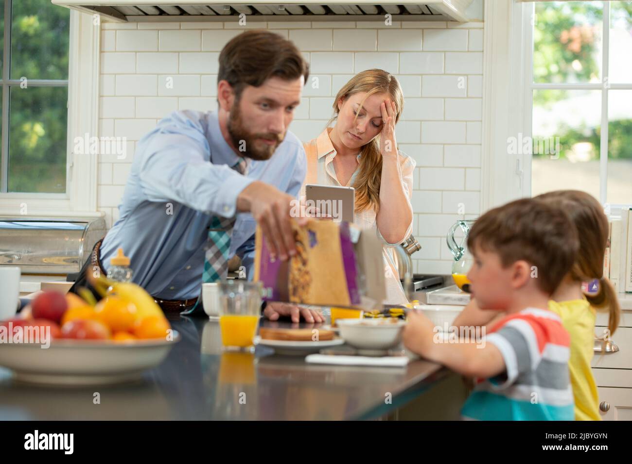 Mom with family in kitchen, struggling to get the kids breakfast and ...