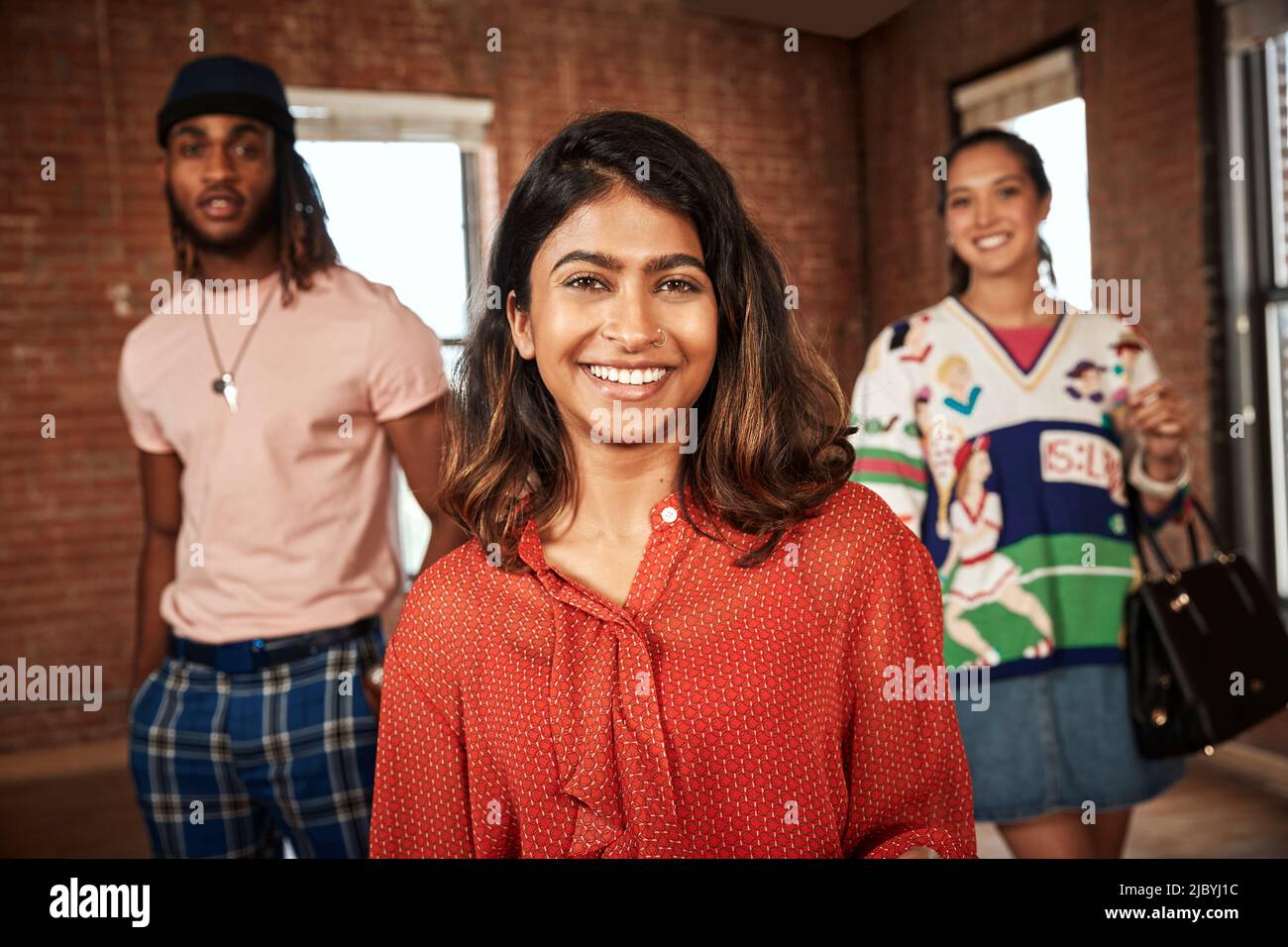Group of friends in empty loft space, socially distanced group photo ...