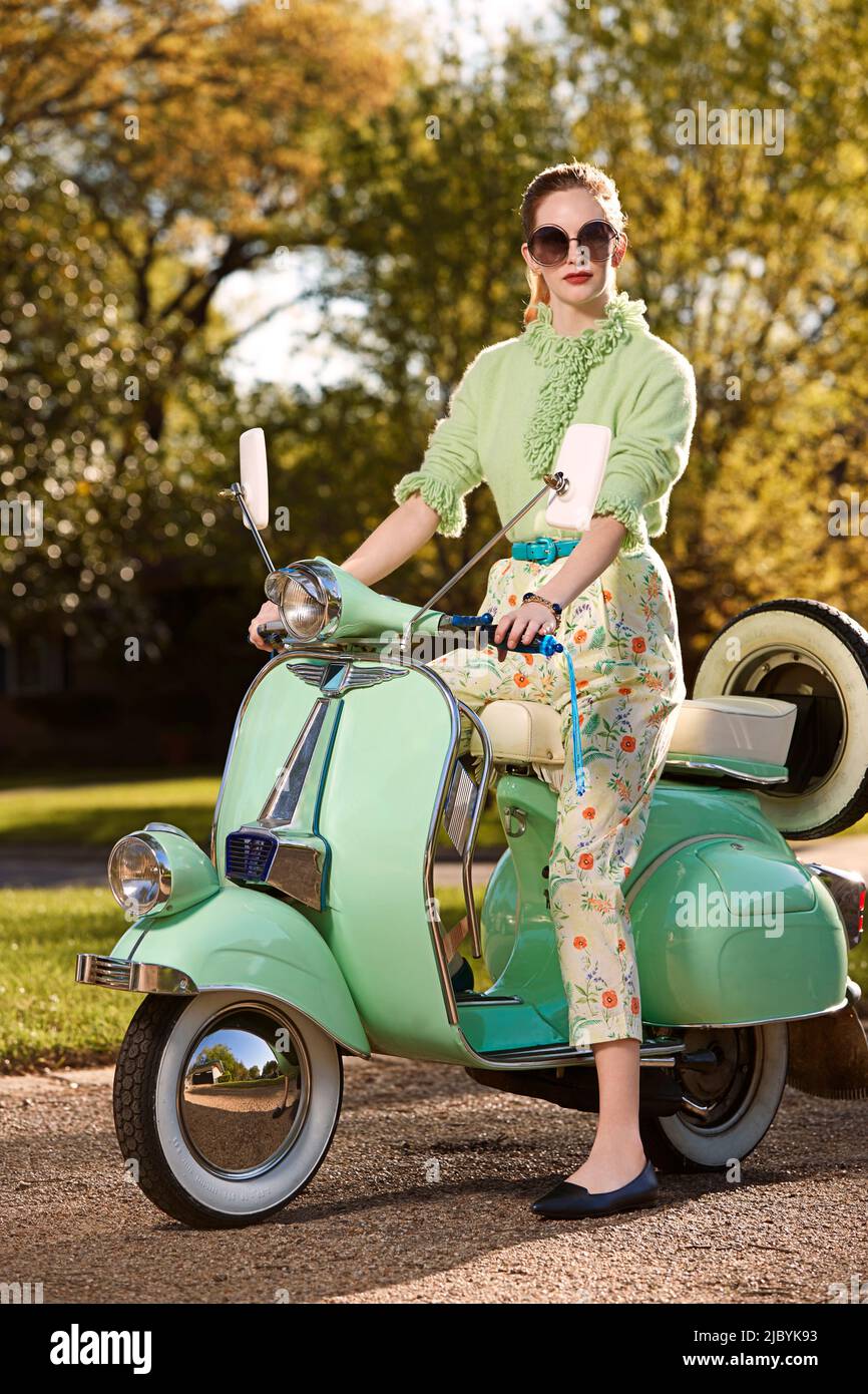 Portrait of woman sitting on vespa outside in a driveway Stock Photo ...