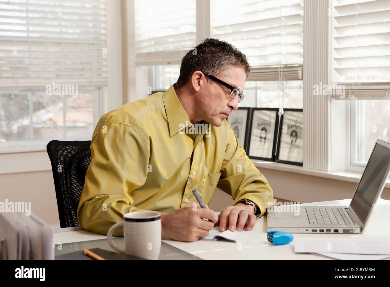 Hispanic man paying bills at desk Stock Photo - Alamy