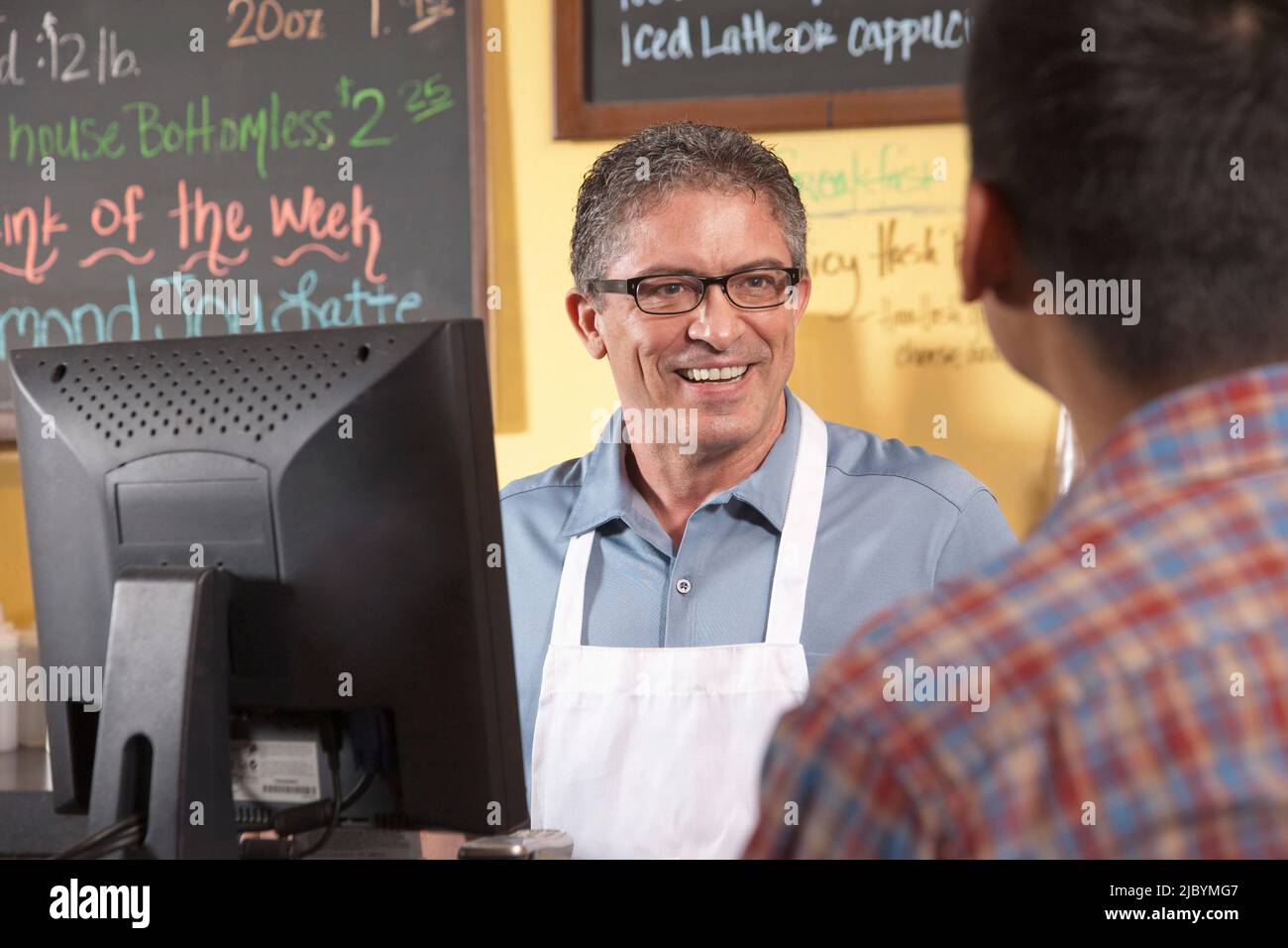Cafe owner serving customer Stock Photo - Alamy