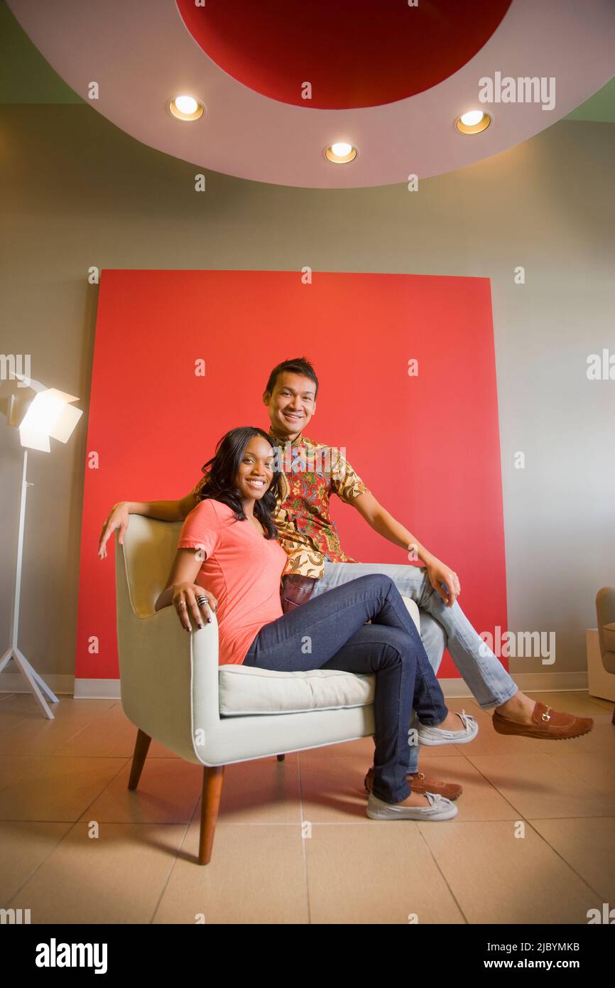 Friends sitting together in armchair Stock Photo - Alamy