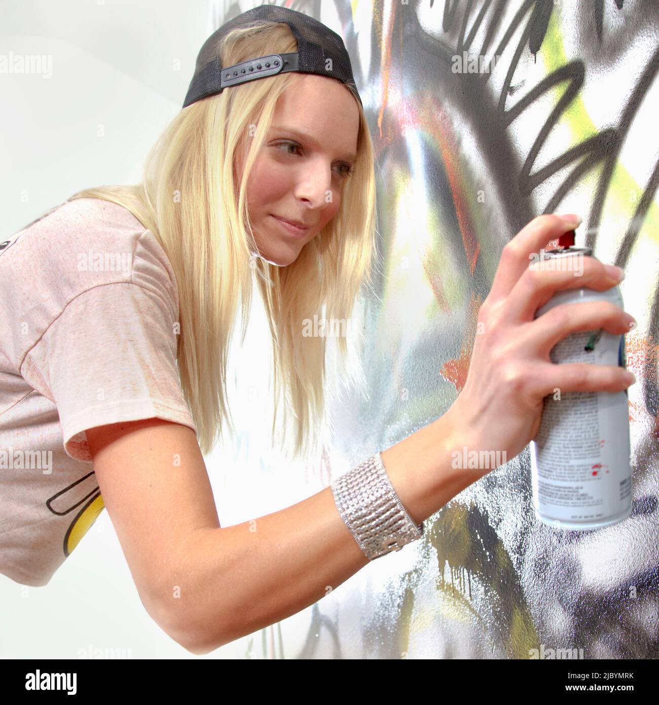 Caucasian woman tagging wall with graffiti Stock Photo - Alamy