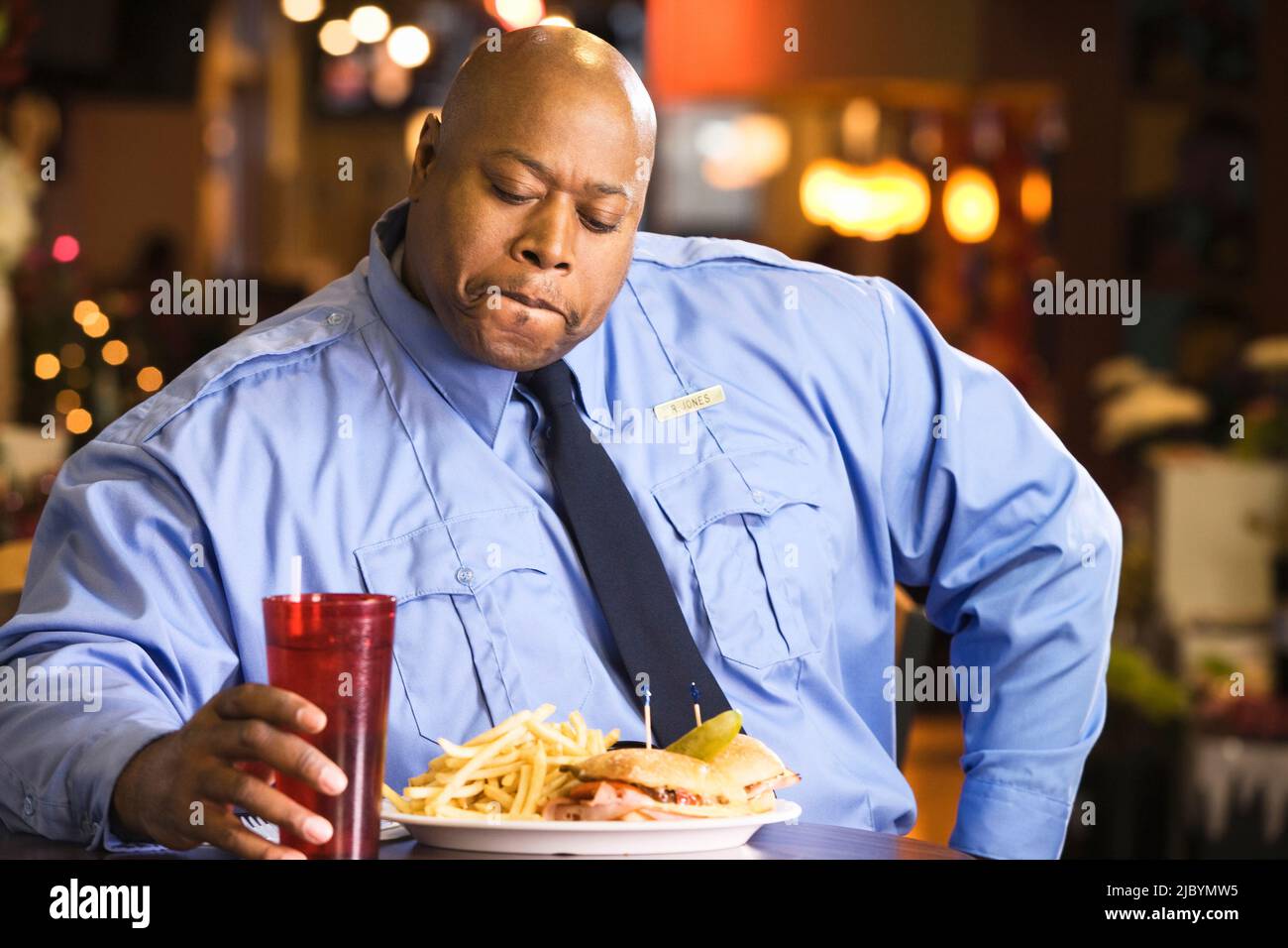 Black police officer eating unhealthy food Stock Photo - Alamy