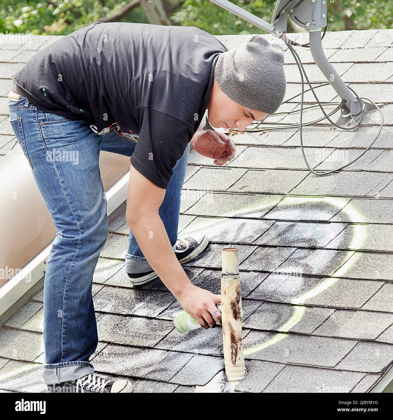 Man tagging roof with graffiti Stock Photo - Alamy