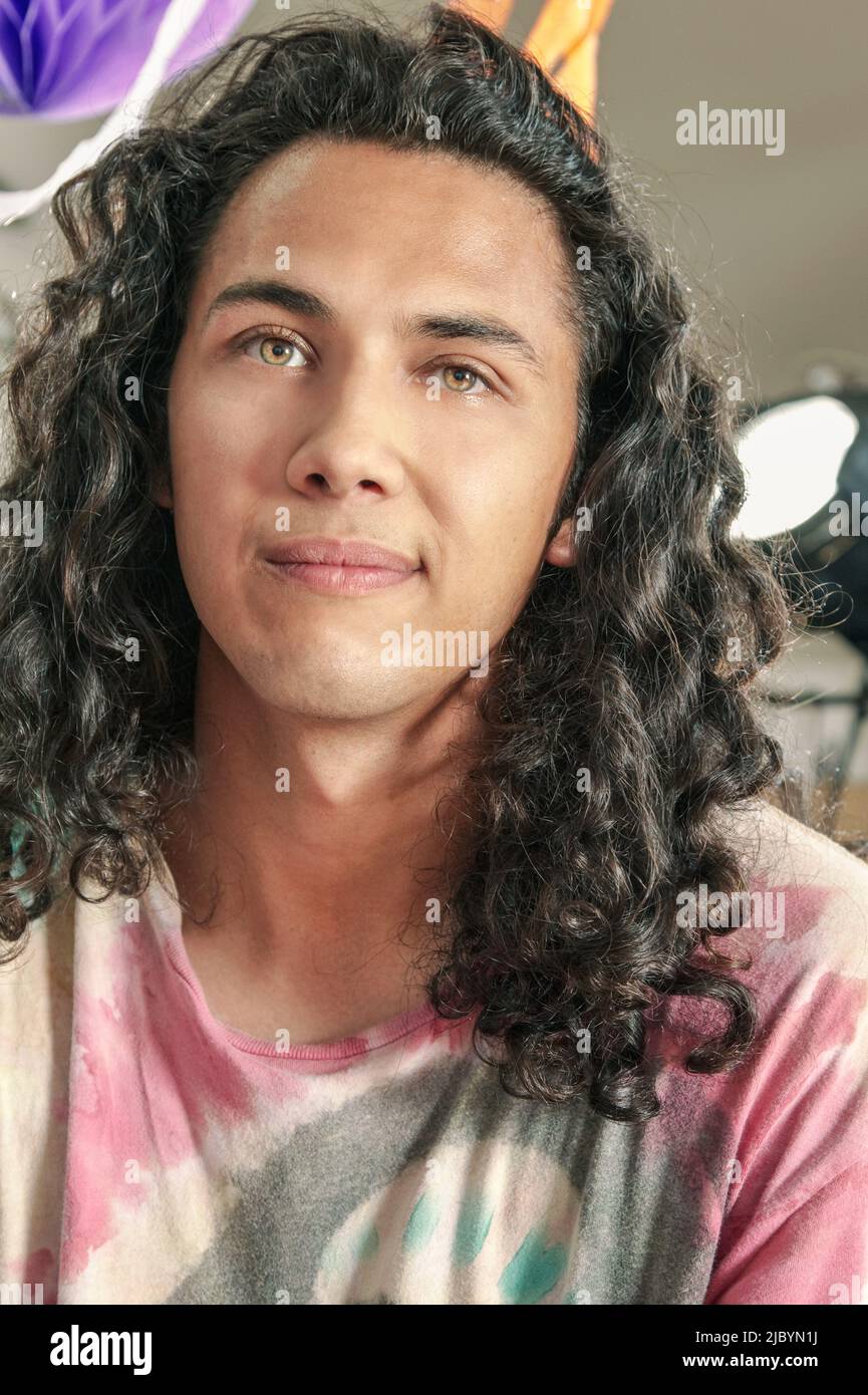 Serious Hispanic man with long, curly hair Stock Photo - Alamy