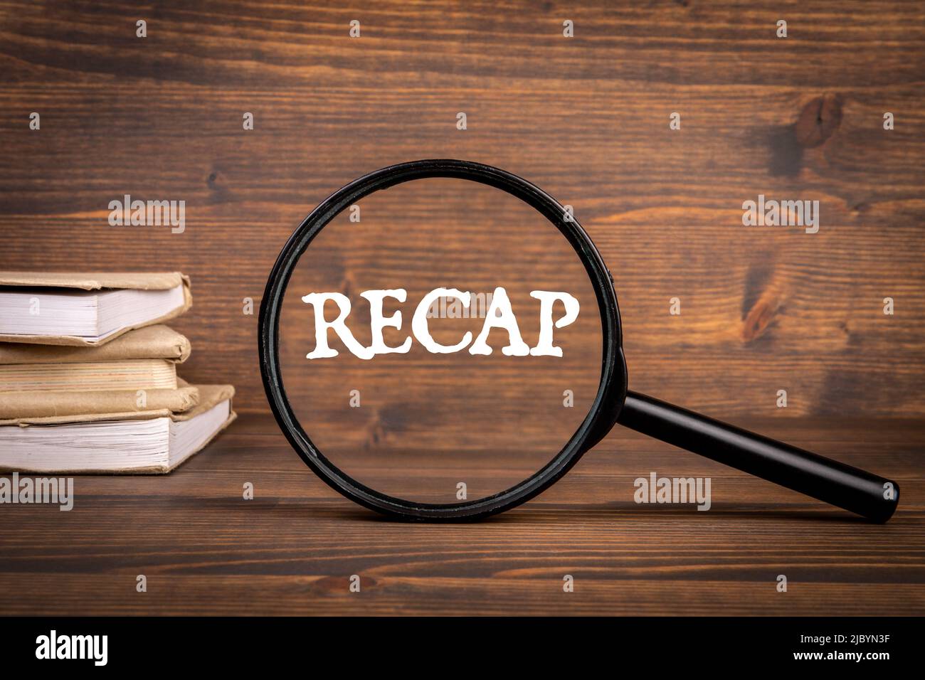 Recap concept. Magnifying glass and books on a wooden background Stock ...