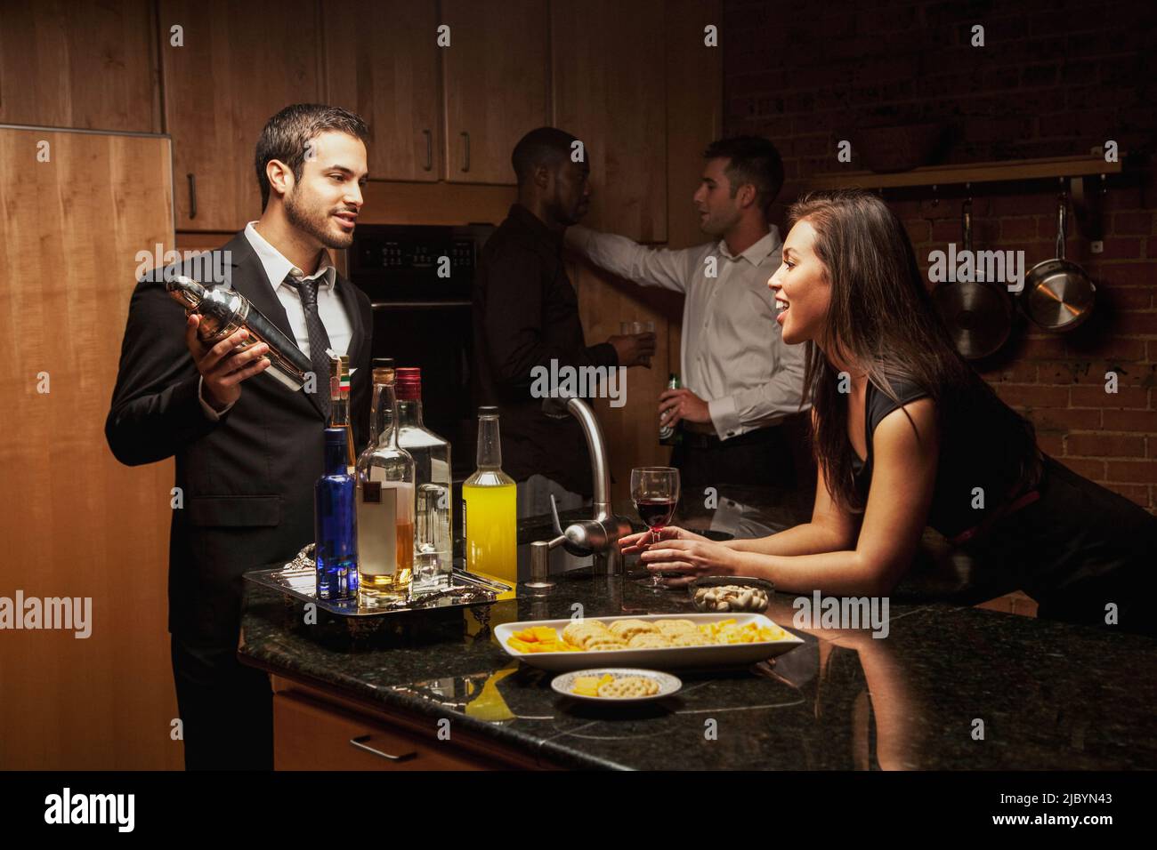 Friends drinking in kitchen at party Stock Photo - Alamy