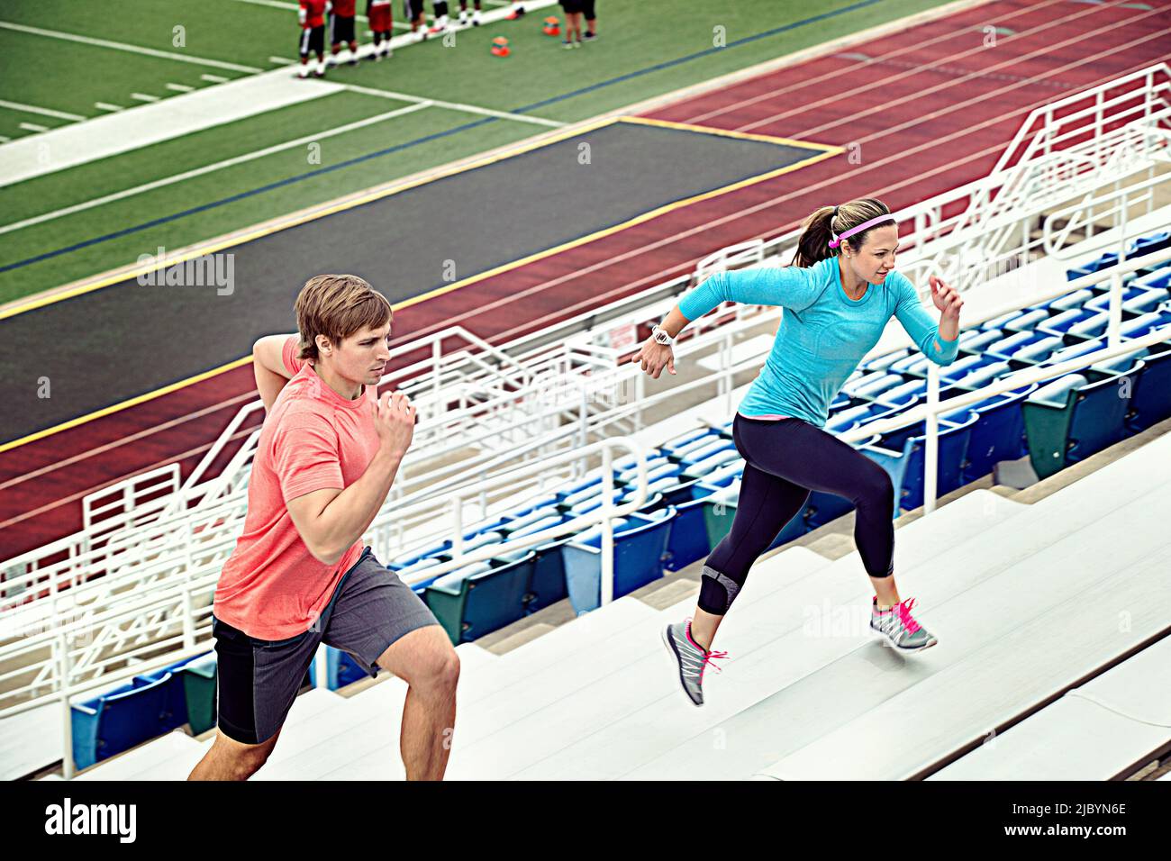 Caucasian athletes running up bleachers Stock Photo - Alamy