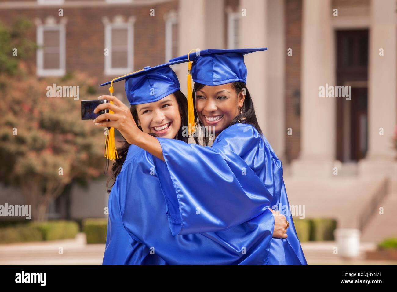 Portrait two female graduates hugging hi-res stock photography and ...