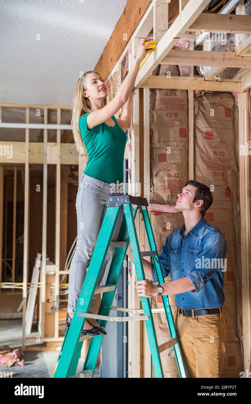 Caucasian couple working at construction site Stock Photo - Alamy