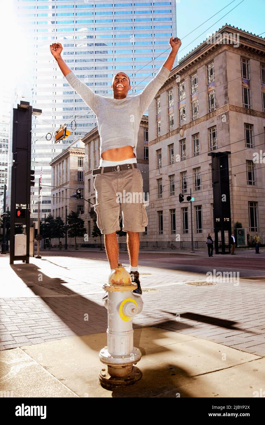 Man standing on fire hydrant on street corner Stock Photo - Alamy