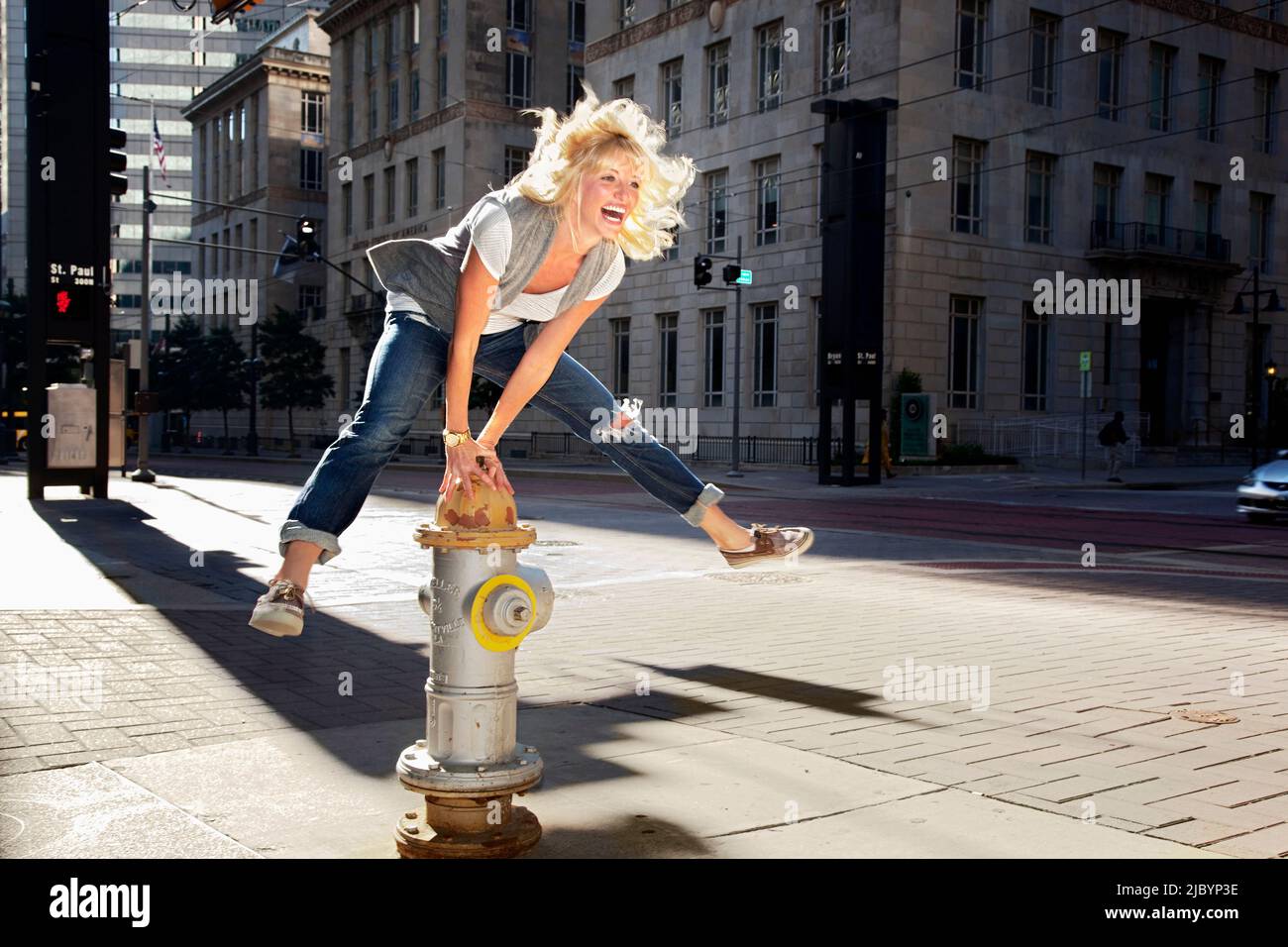 Caucasian woman jumping over fire hydrant Stock Photo - Alamy