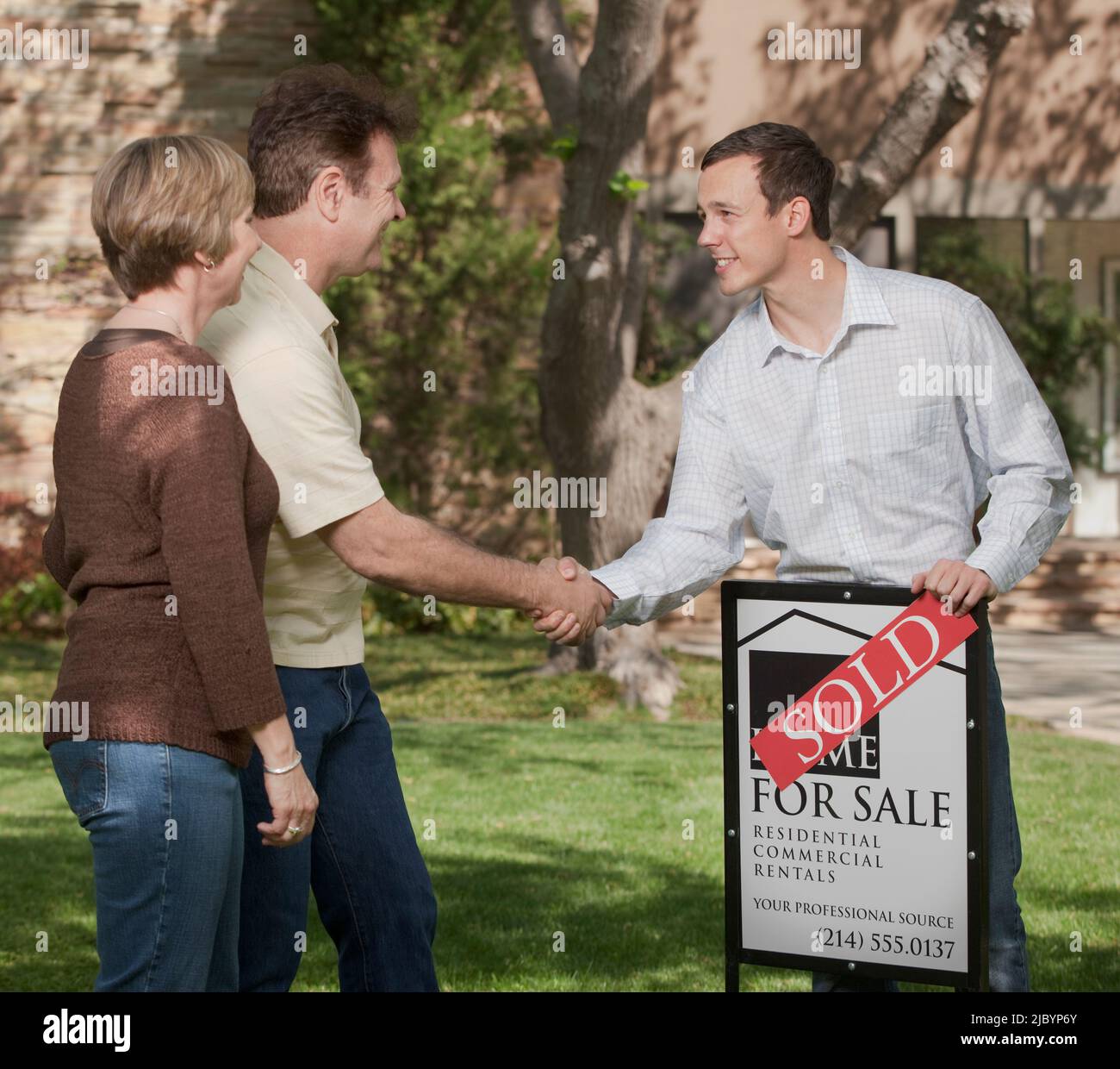Couple shaking hands with real estate agent Stock Photo - Alamy