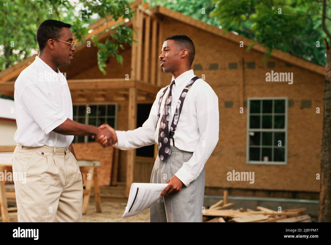 African businessmen shaking hands outside new home Stock Photo - Alamy