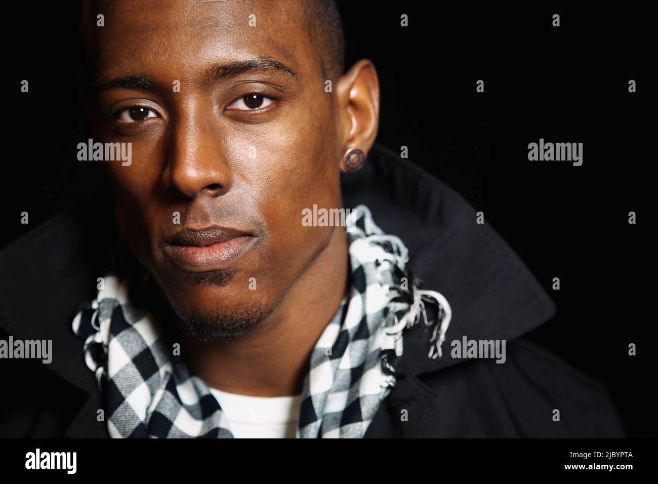 Serious African man in trench coat Stock Photo - Alamy