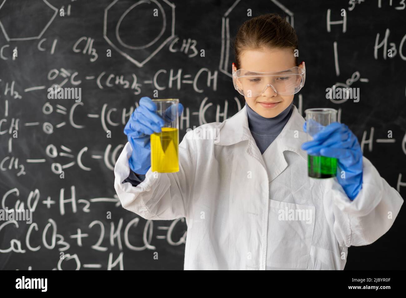 young girl making science experiments in laboratory. student doing a ...
