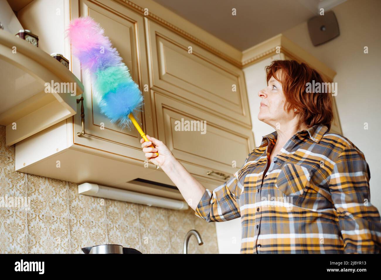 Woman dusting cupboard hi-res stock photography and images - Alamy