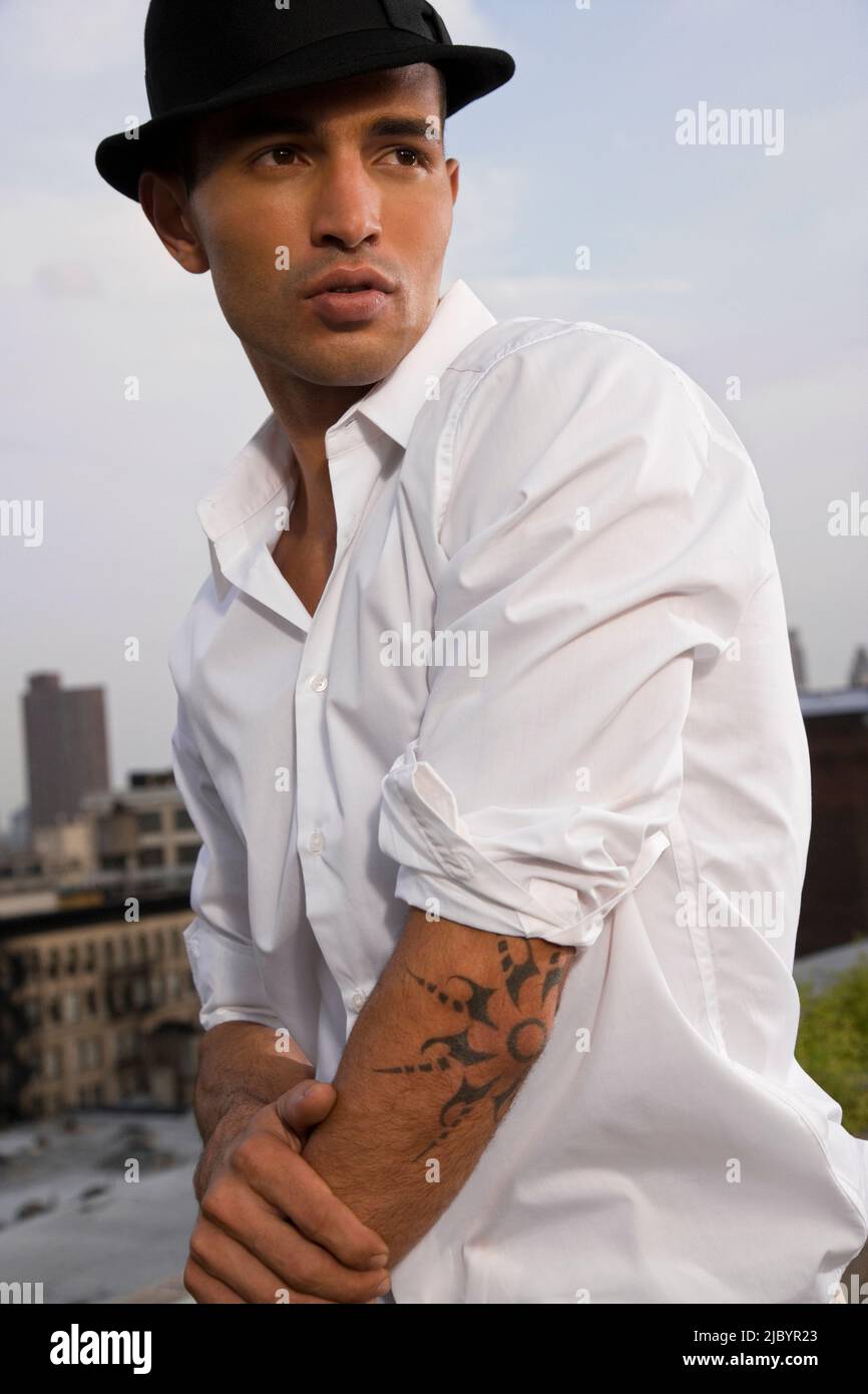Hispanic man with tattoo wearing fedora Stock Photo - Alamy
