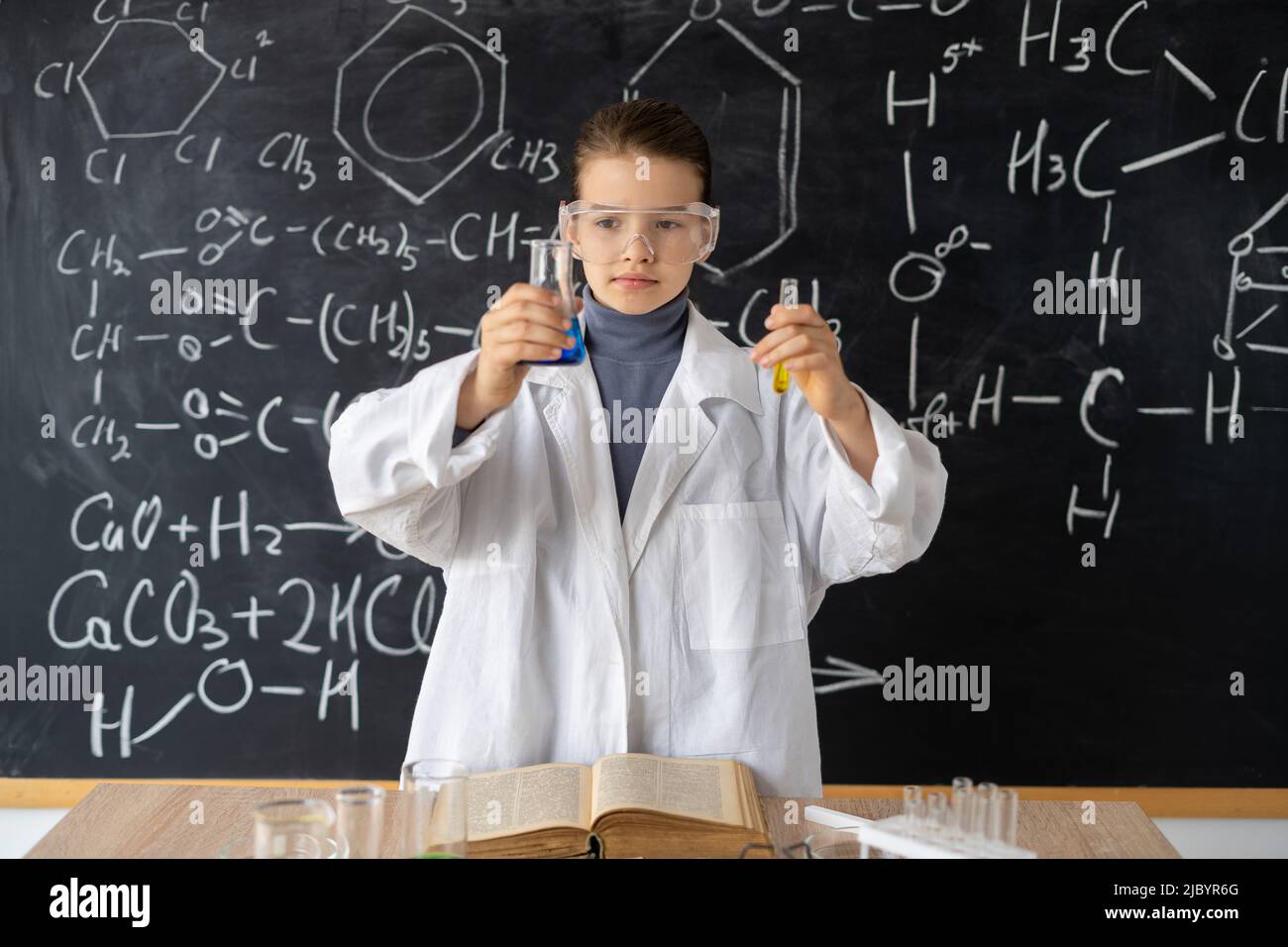 Female pupil conducting chemistry experiment. little student on ...
