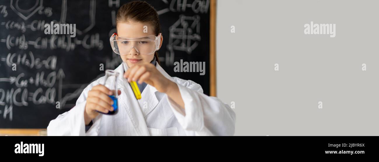 little student on chemistry lesson in lab doing an experiment, girl ...